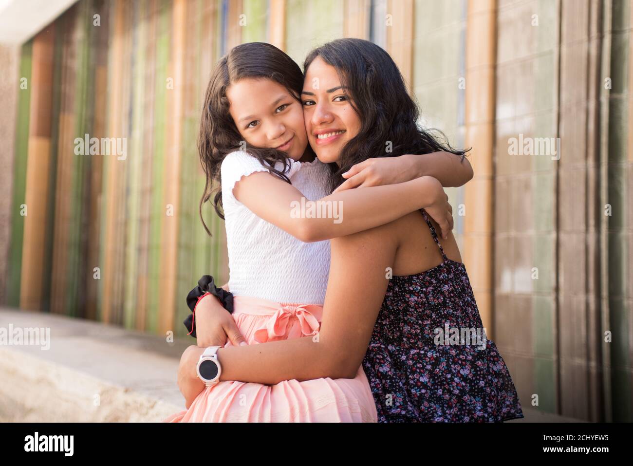 Young mother hugging her happy daughter Stock Photo - Alamy