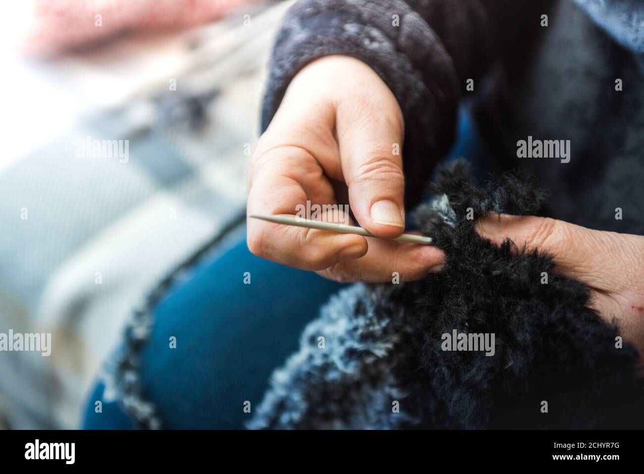 Closeup shot of female hands knitting with a fluffy fabric Stock Photo ...
