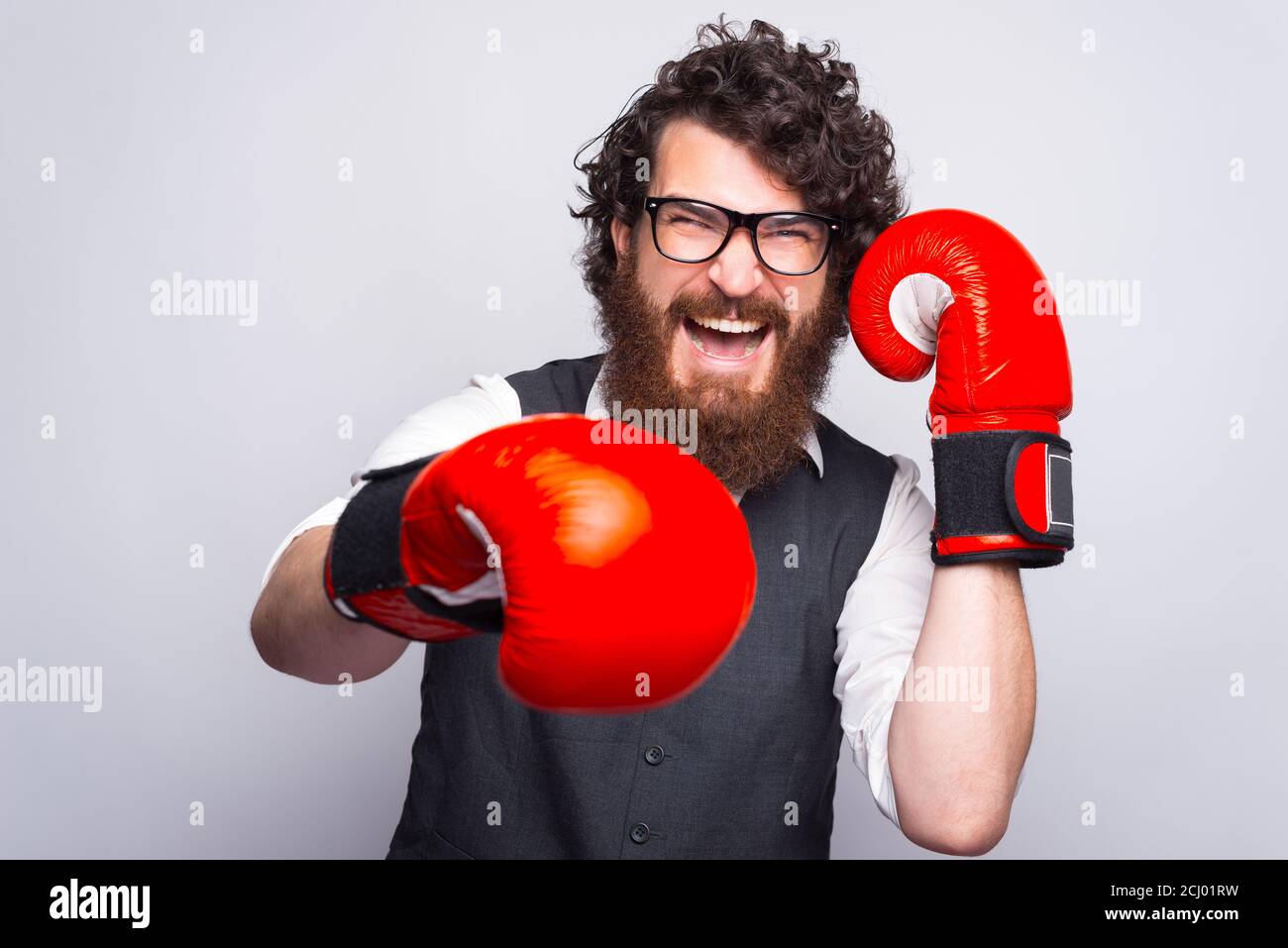 Photo of man with beard wearing suit and punching with boxing gloves ...