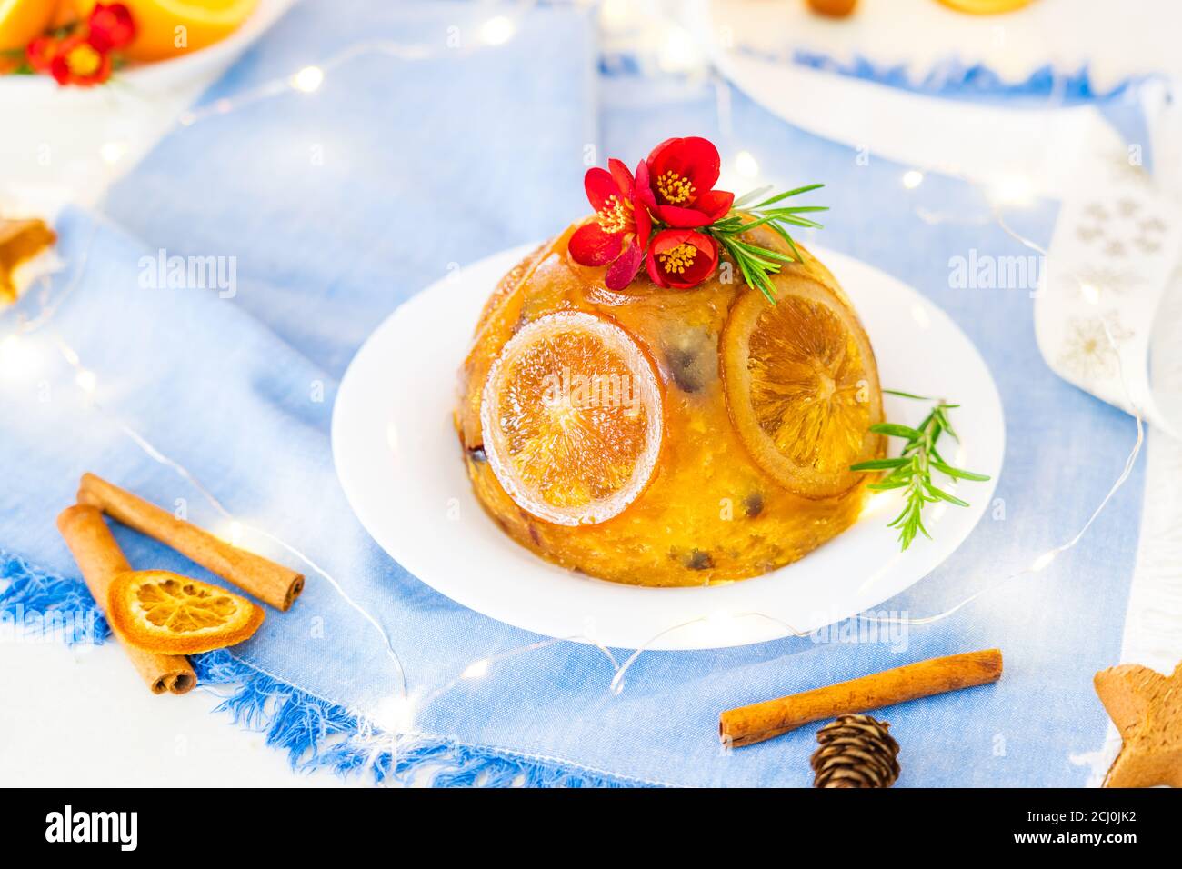 Traditional English Christmas pudding decorated with oranges and fresh ...