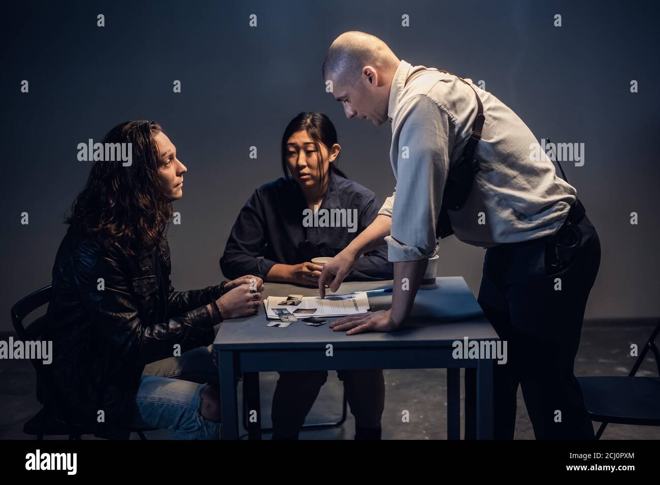 Two police officers are questioning a man with a tattooed face and long ...