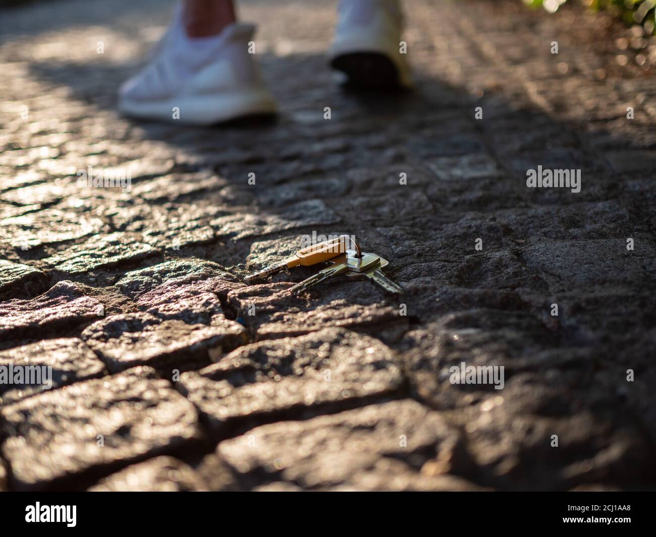 A man walking away after losing his keys on the sidewalk Stock Photo ...
