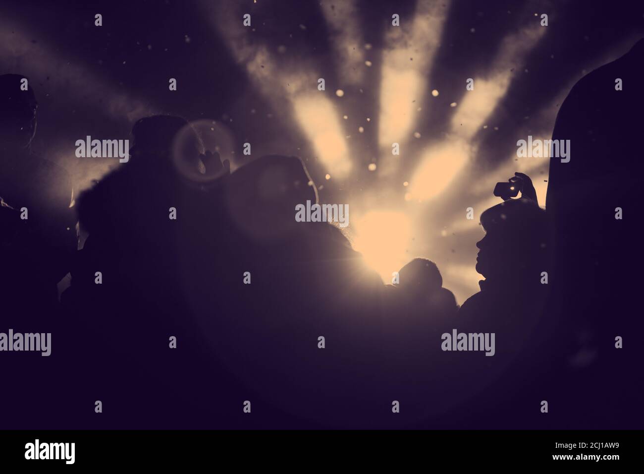 Sun-shaped light illuminating silhouettes in the darkness Stock Photo ...