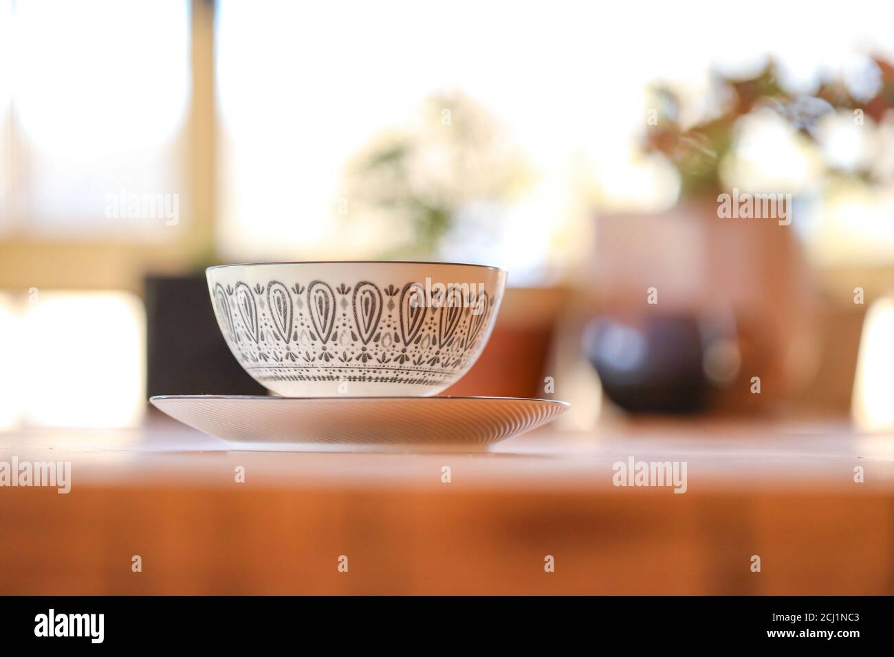 Cup and saucer on display on kitchen table with vibrant window light ...