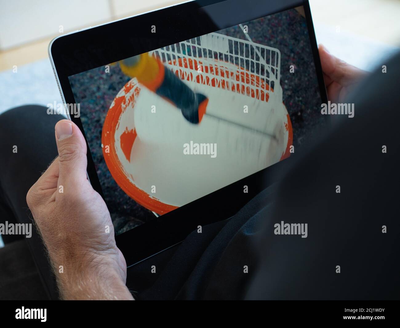 Man watching a YouTube video on tablet (iPad Pro) with craftsman ...
