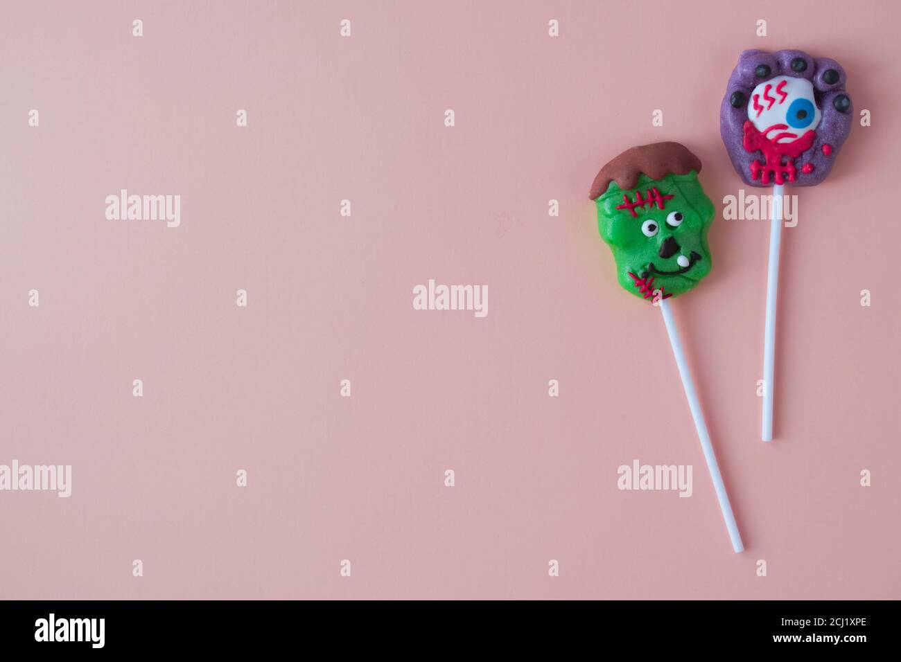 Two scary heluin lollipops lie on a pink background Stock Photo - Alamy