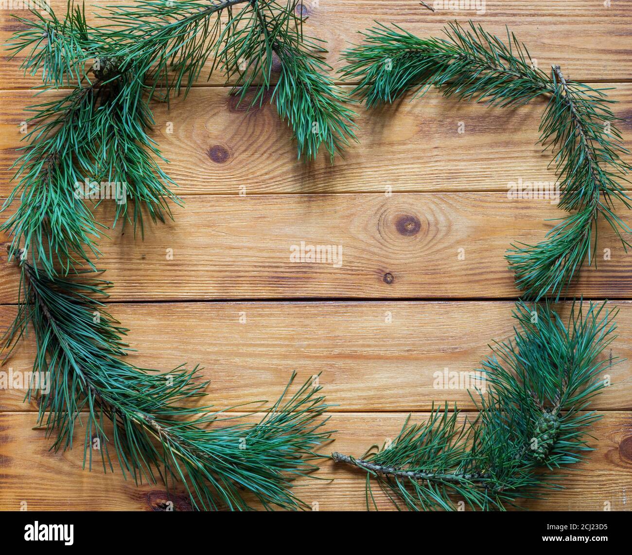 frame of pine branches with cones on a wooden background Stock Photo ...