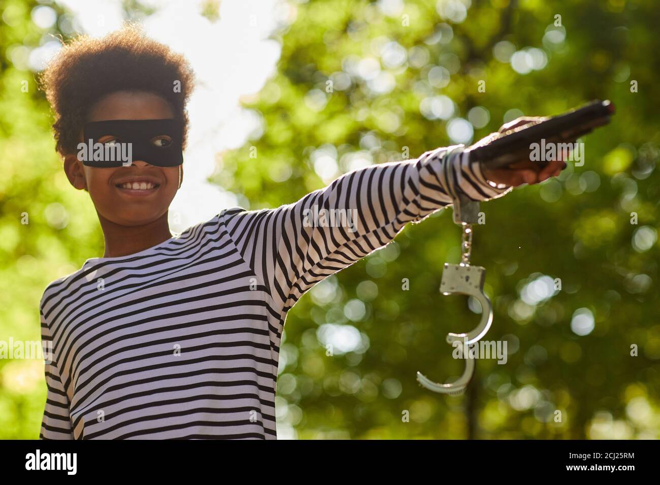 Waist up portrait of smiling African-American boy wearing bandit ...