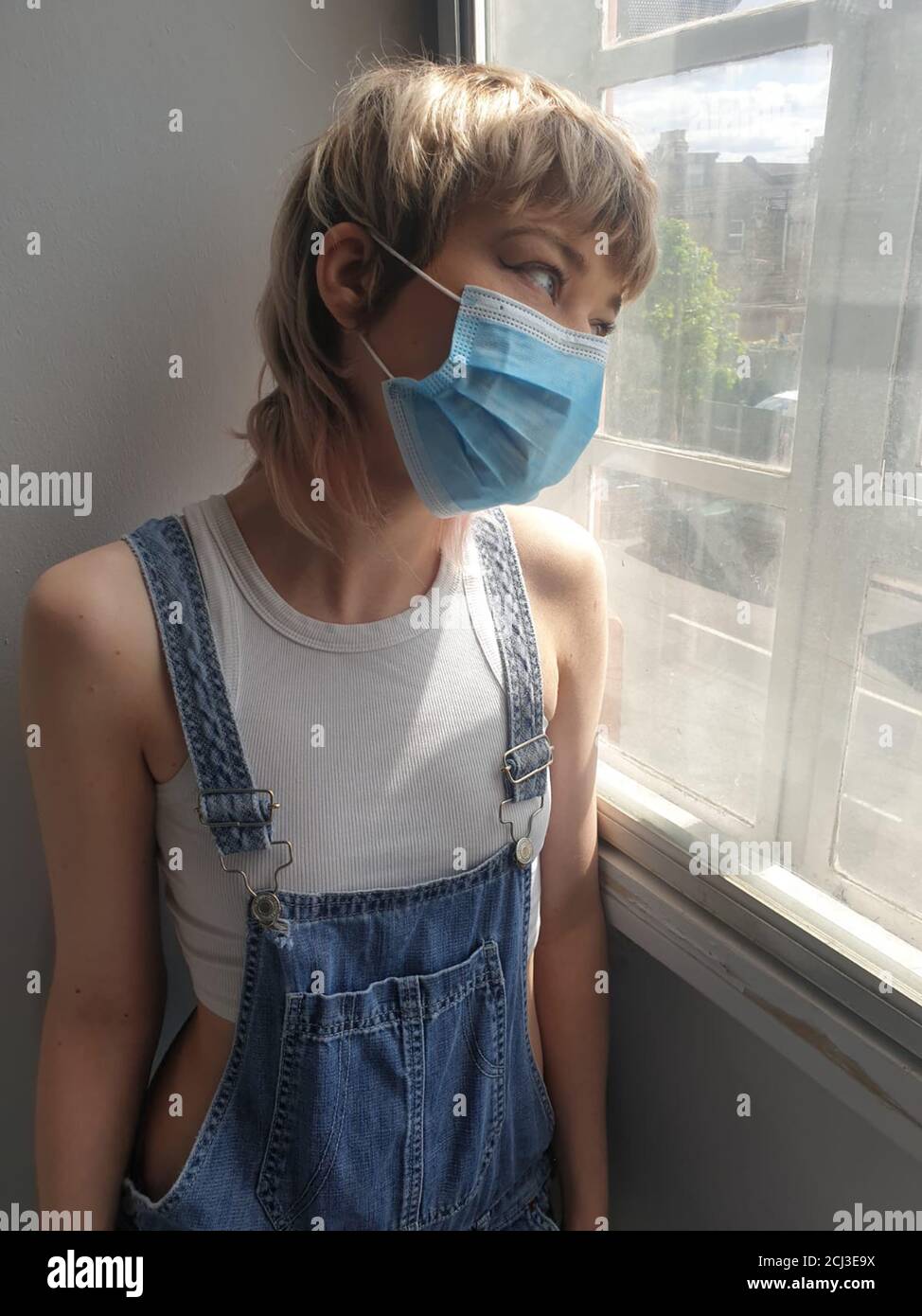 Girl isolated and alone at home wearing medical mask Stock Photo - Alamy