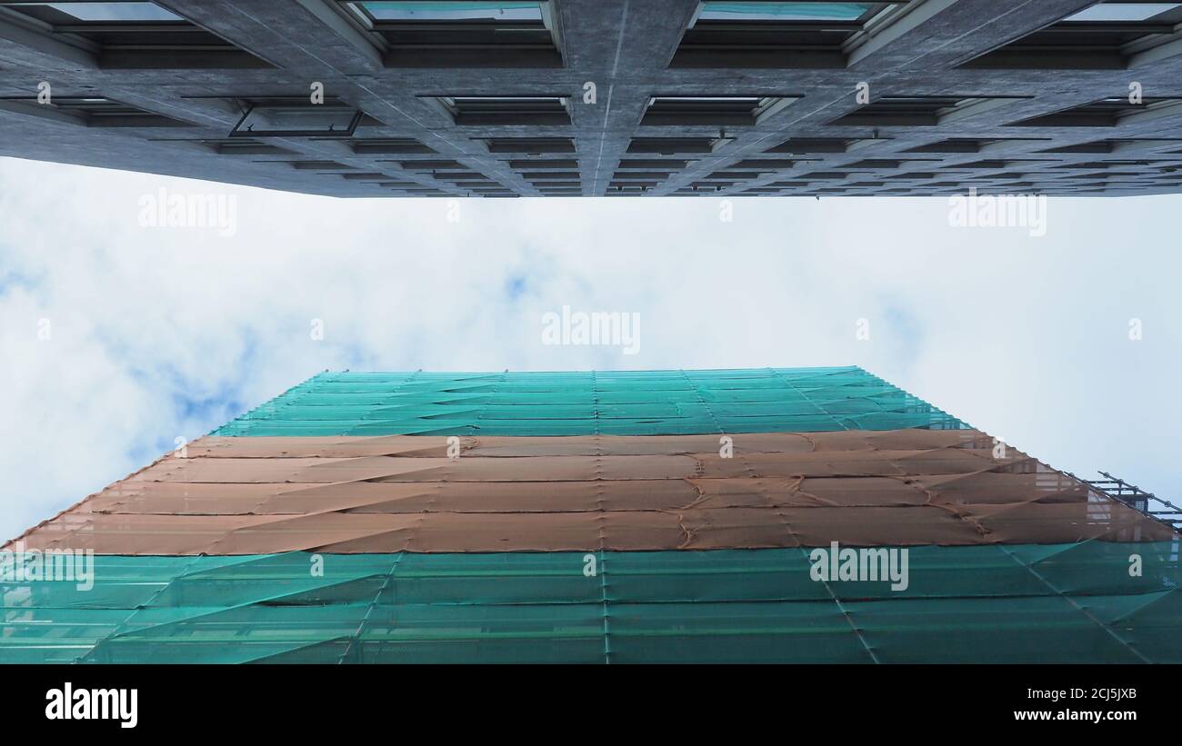 Street view of a complete city building and a building being worked on ...