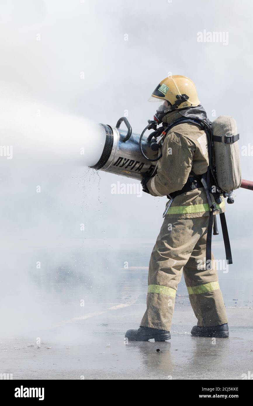 One firefighter extinguish fire from fire hose, using firefighting ...