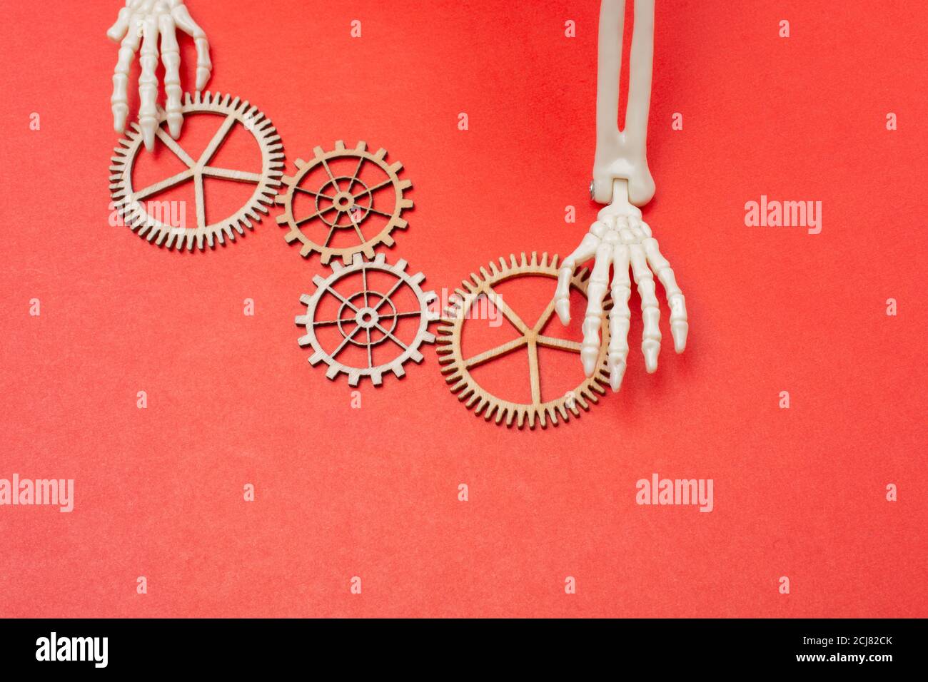 Skeleton hand pressing on man figurine on red . Death concept Stock ...