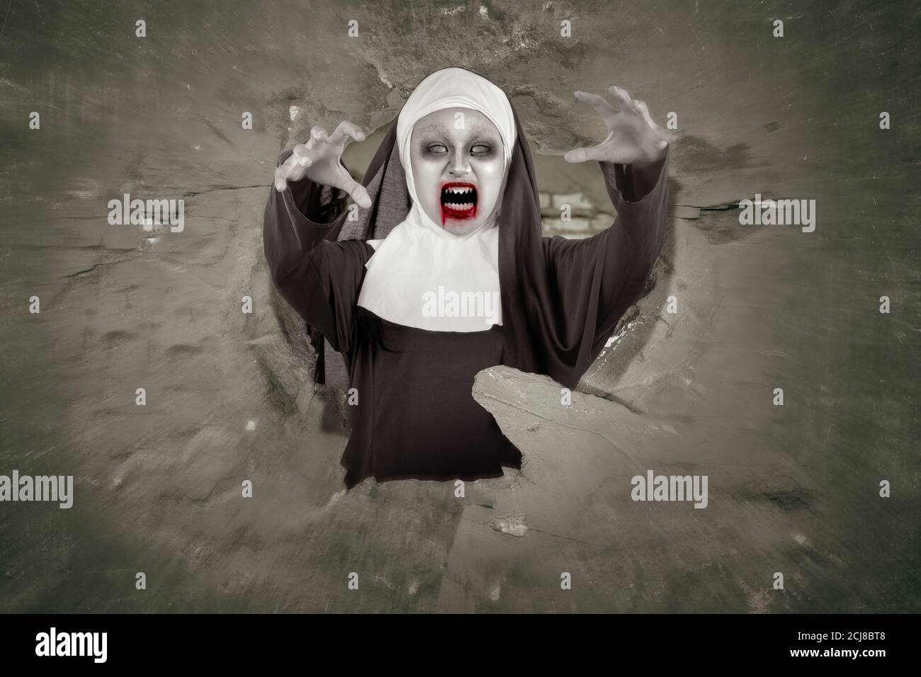Scary devil nun coming out from a hole in the wall Stock Photo - Alamy