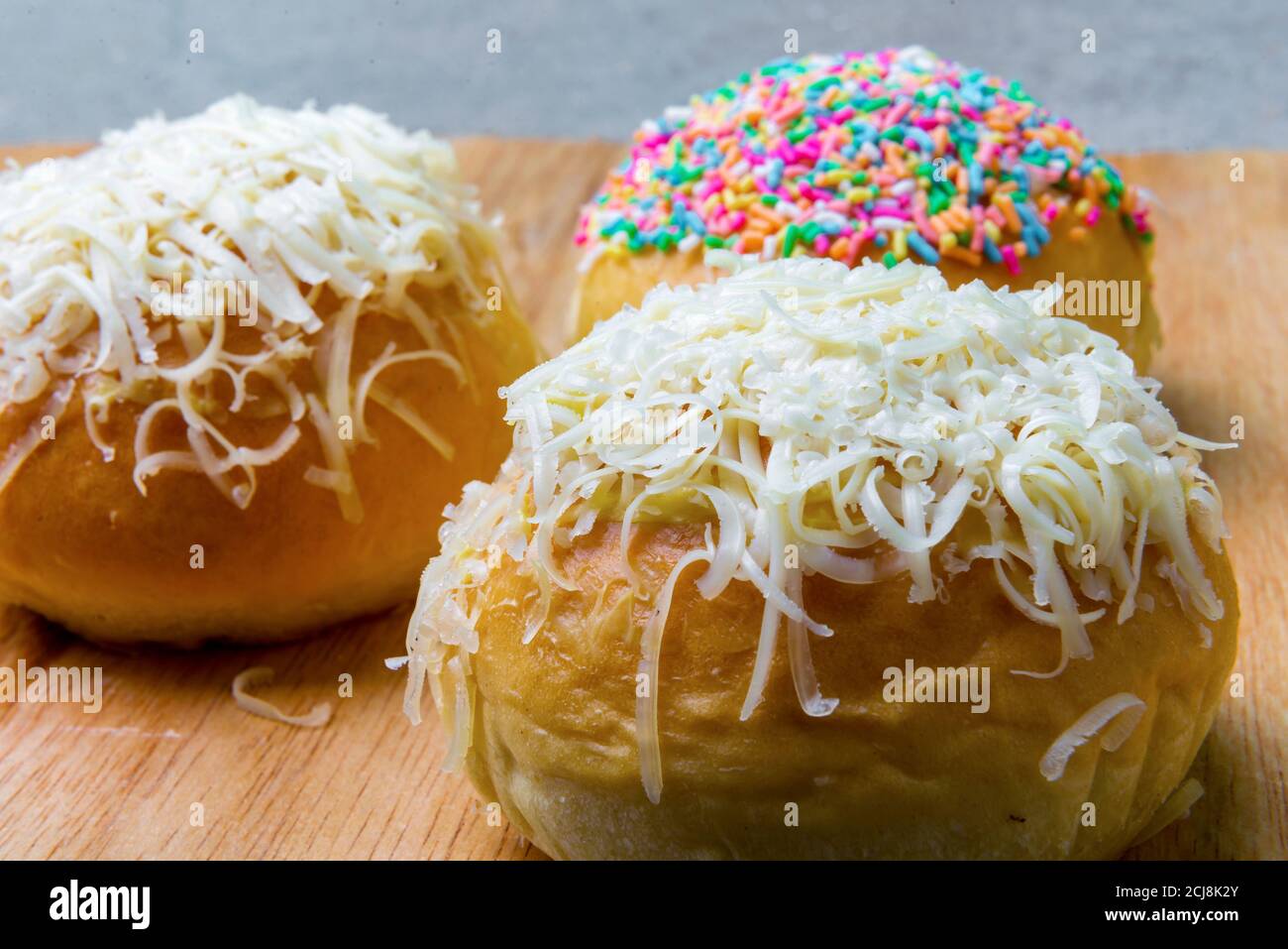 Cake with colorful sprinkles and grated cheese on wooden table Stock ...