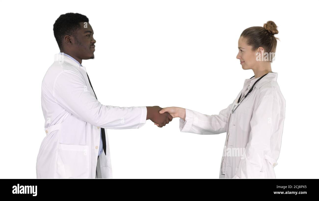 Two young doctor shaking hands on white background Stock Photo - Alamy
