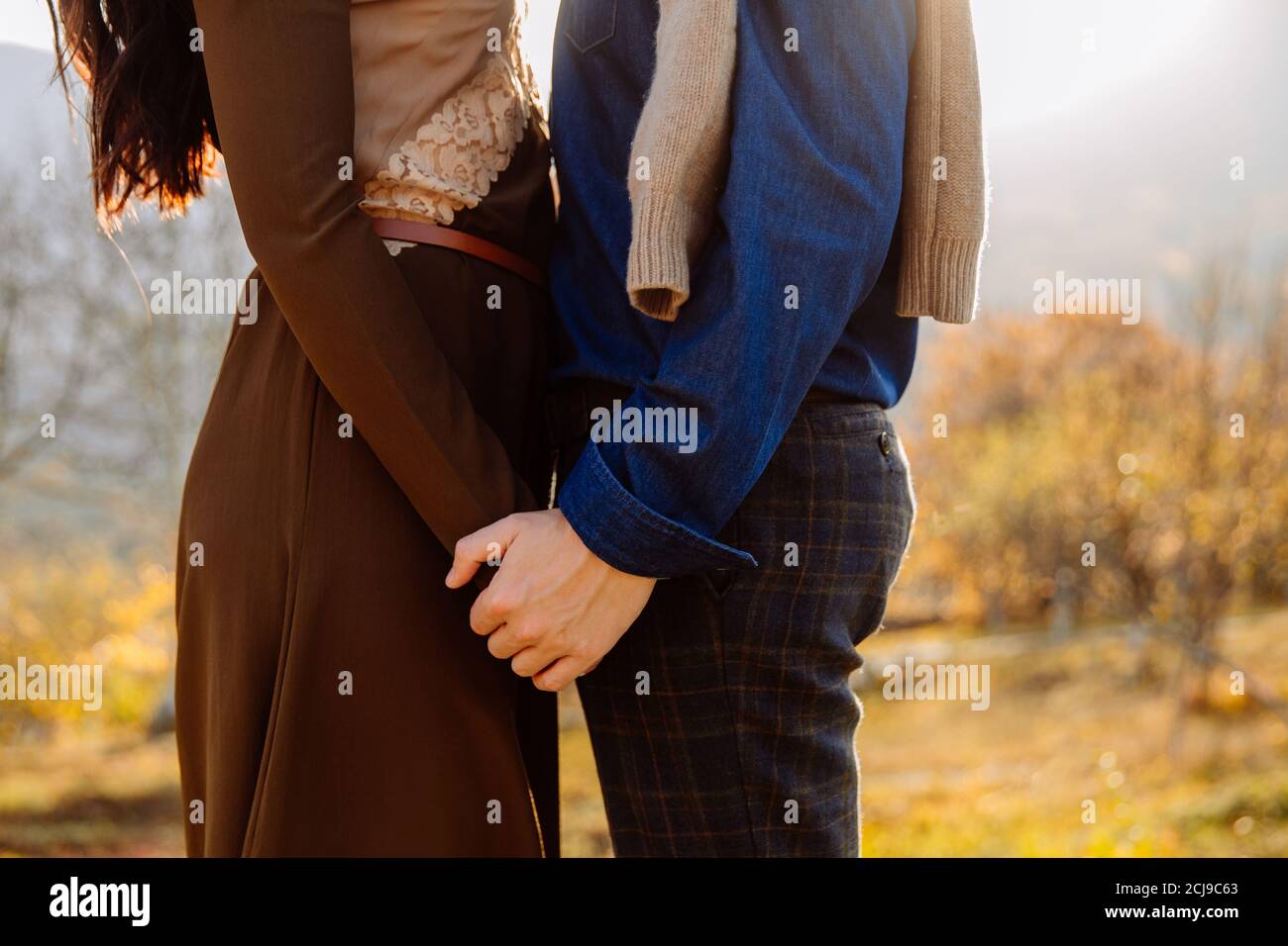 Woman and man holding hands. Young couple with scenic nature background ...