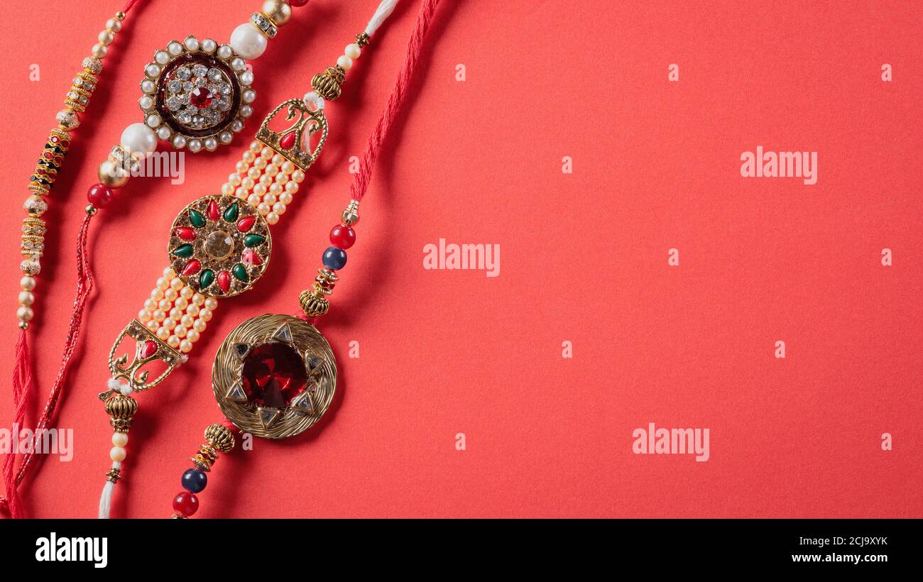 Raksha Bandhan, Indian festival with beautiful Rakhi on red background ...