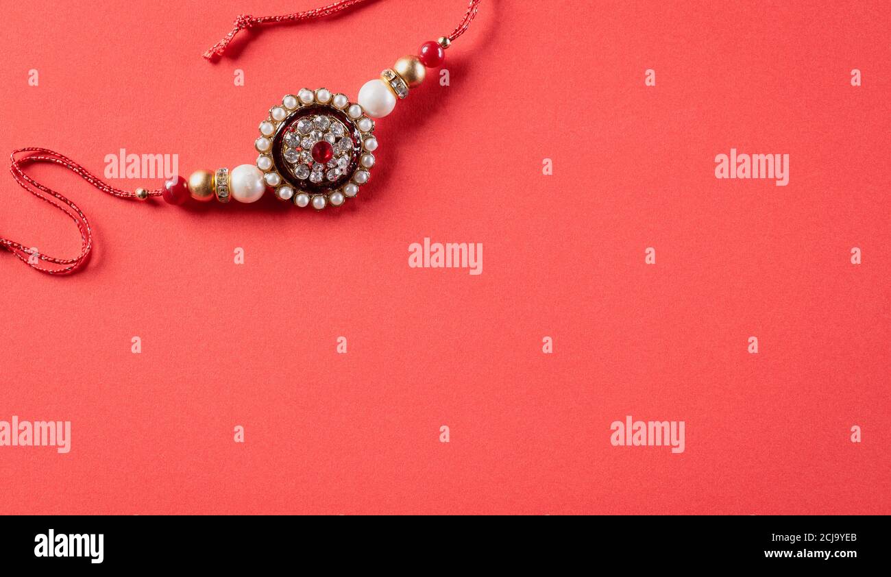 Raksha Bandhan, Indian festival with beautiful Rakhi on red background ...