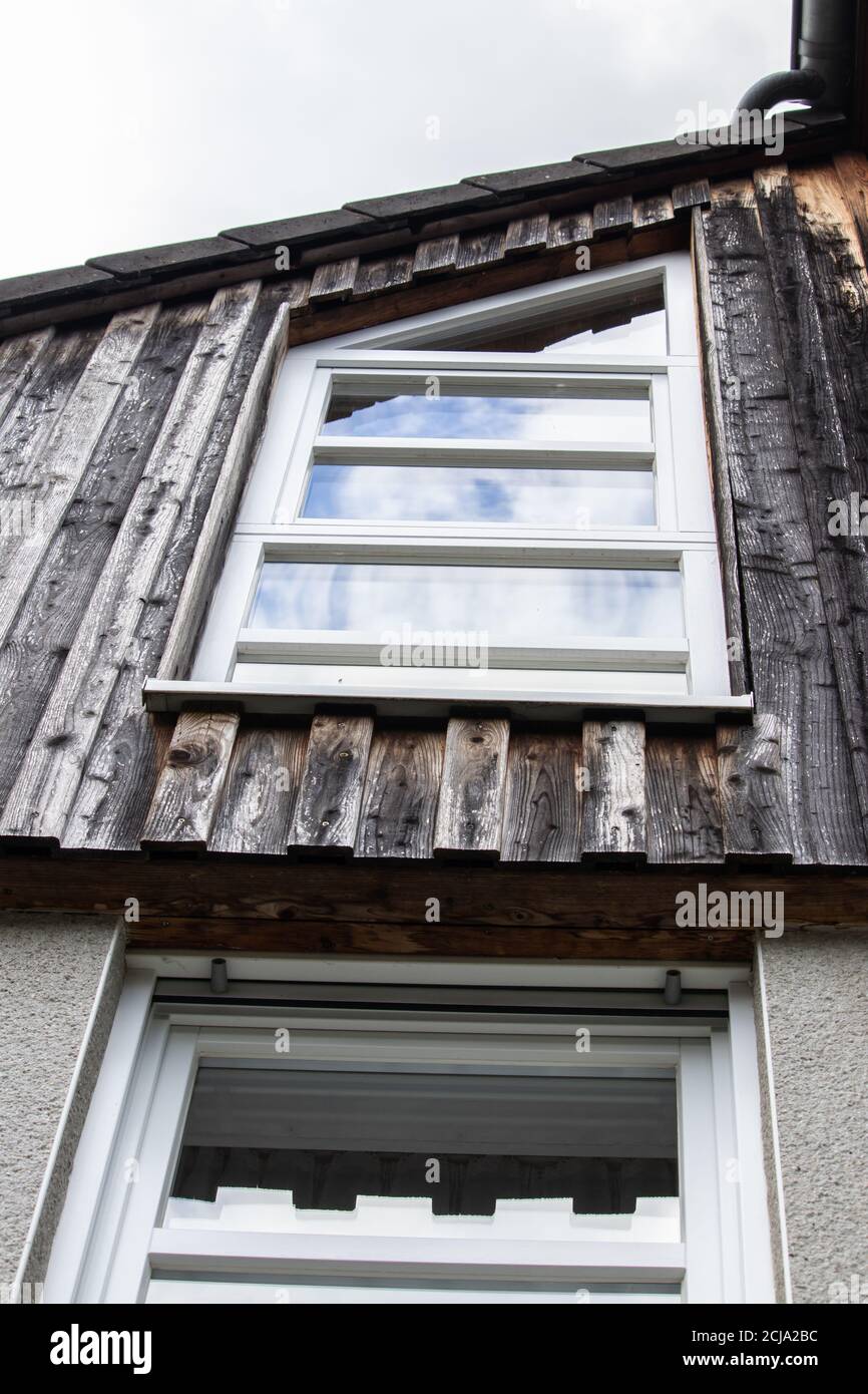 Vertical low angle shot of a wooden house with a triangular window ...