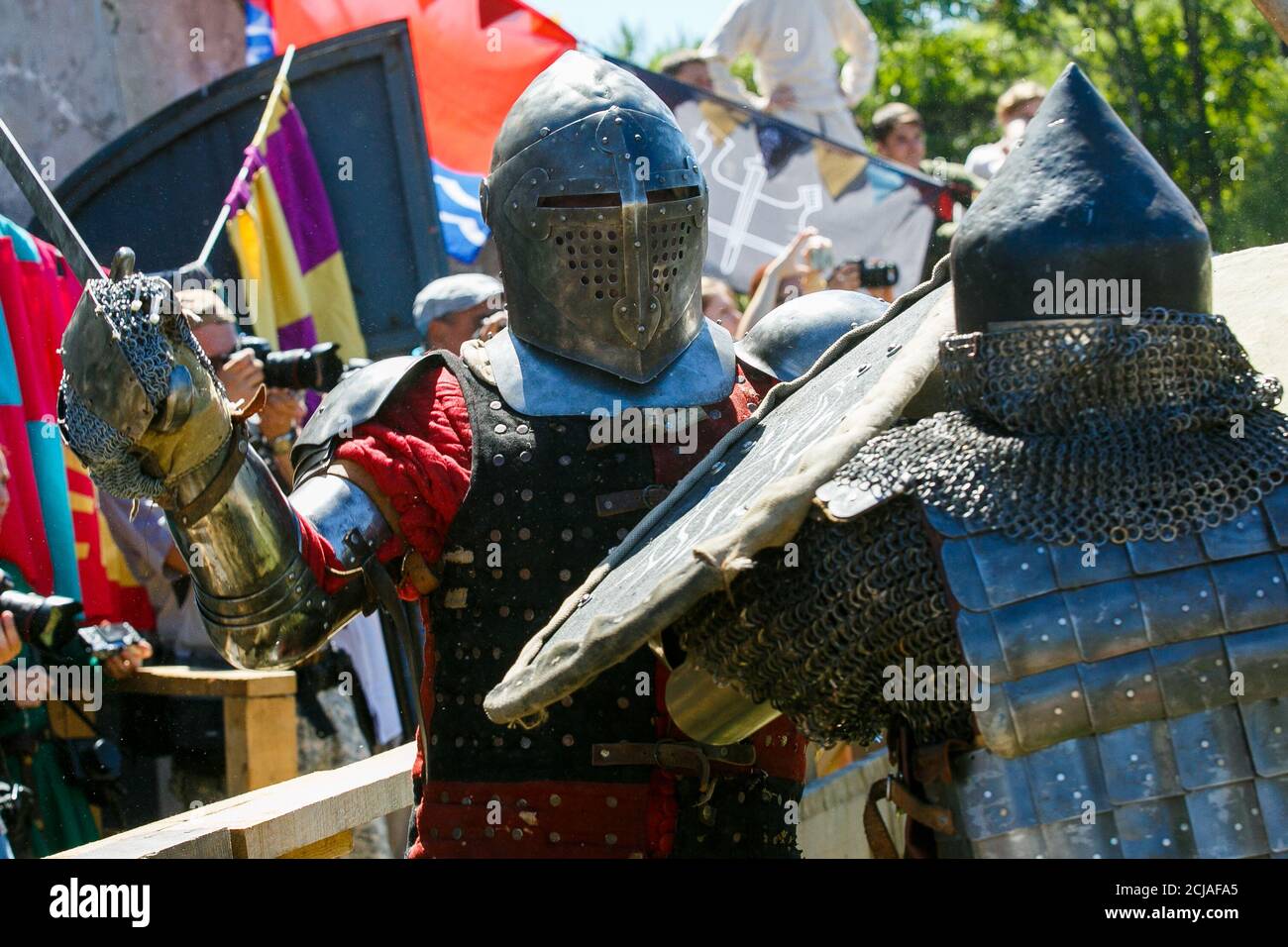 Knight Tournament. Medieval restorers fight with swords in armor at a ...