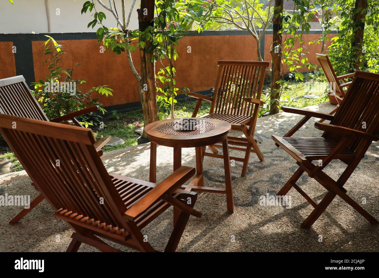 Set of wooden table and chairs in the garden. Teak wood furniture stand ...