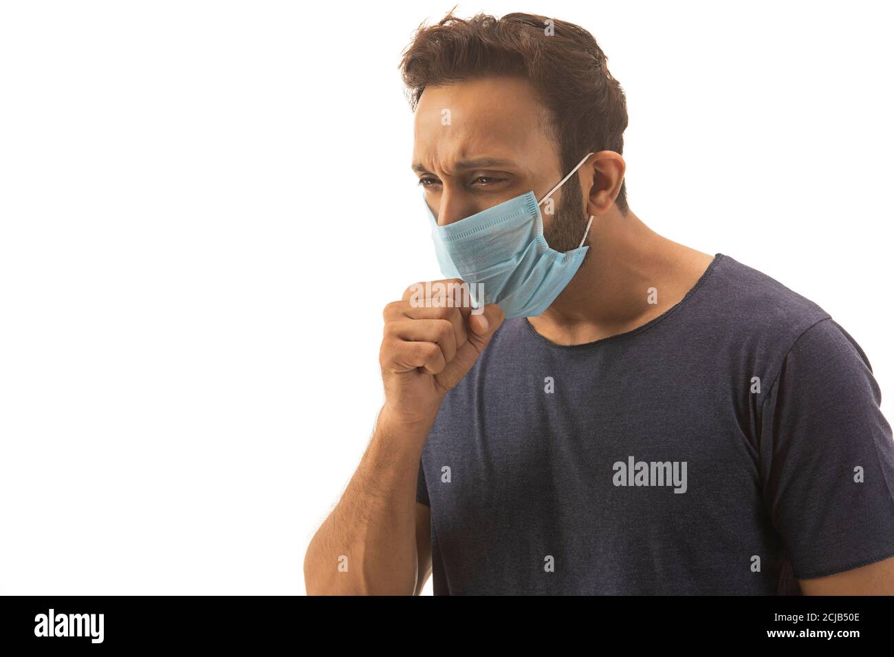 Young man coughing with his mask on Stock Photo - Alamy