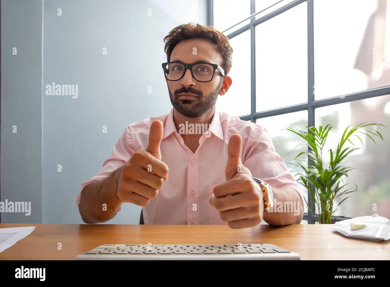 Young man giving a thumbs up while talking on video call Stock Photo ...