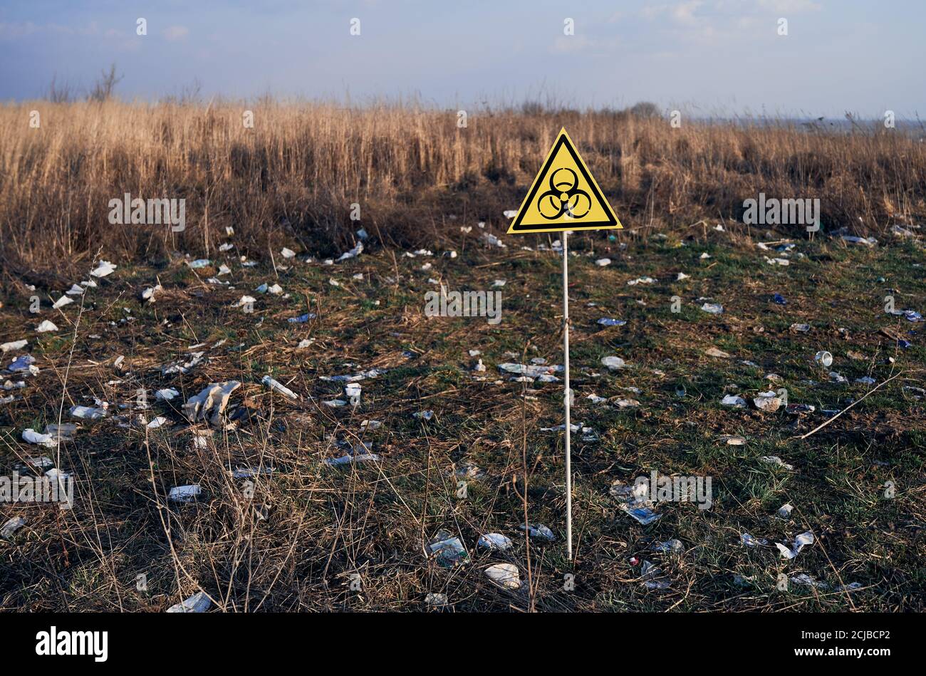 Yellow triangle with biohazard symbol warning on abandoned territory ...