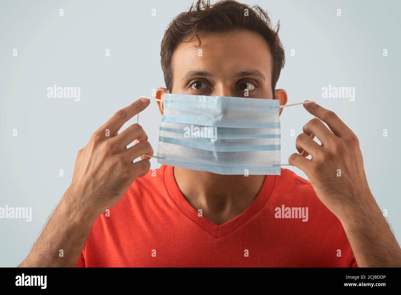 Young man protecting himself from various infections by wearing a mask ...