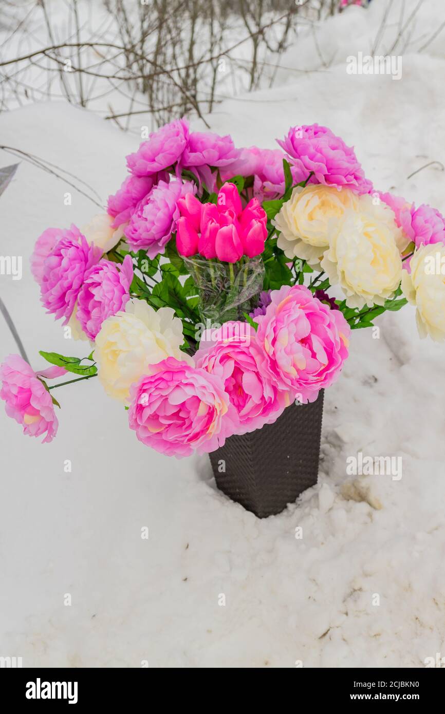 bunch of artificial pink and white peonies in plastic rattan basket on ...