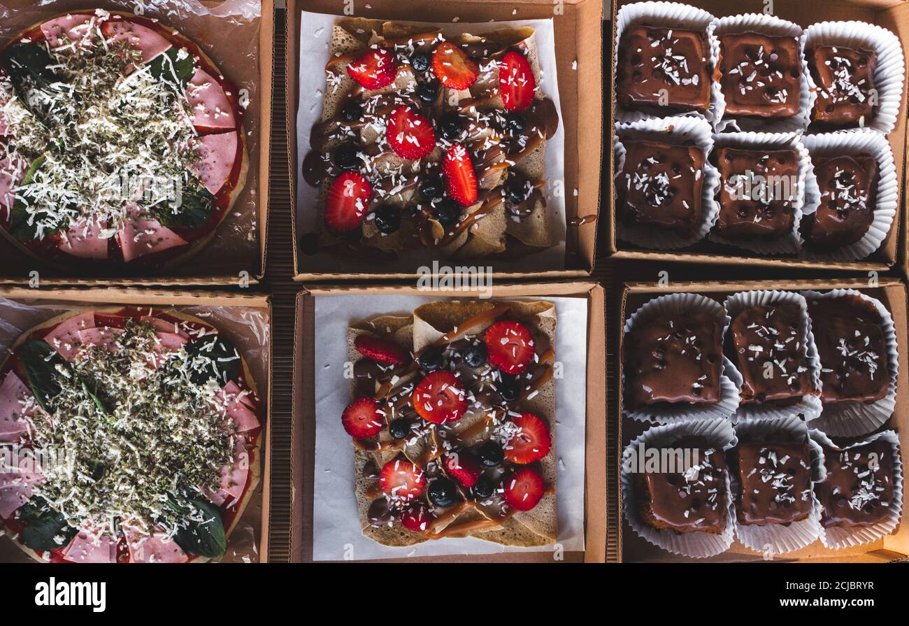 Top view of takeaway food boxes with brownies, crepes, and pizza Stock ...