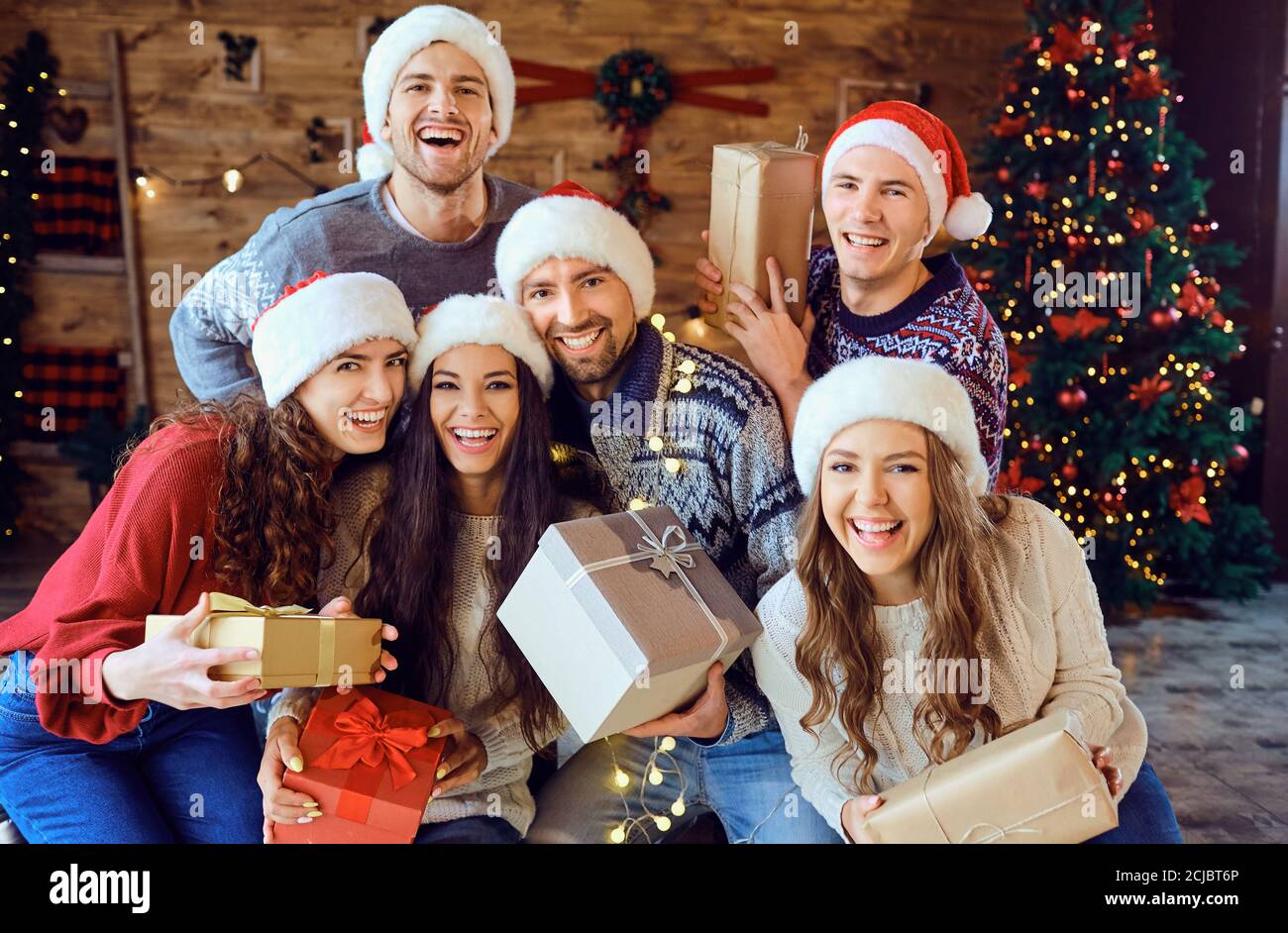 Happy friends with gifts smiling at Christmas Stock Photo - Alamy