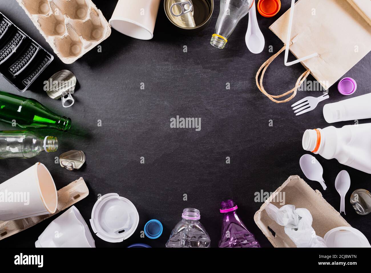Top view of Different garbage materials with recycling symbol on black ...