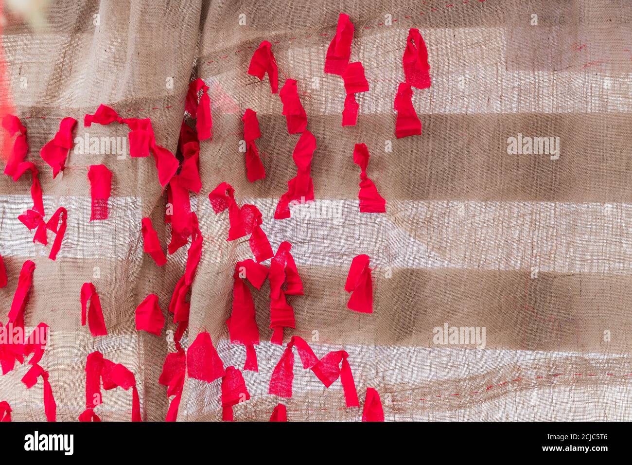 sackcloth background with red pieces of cloth Stock Photo - Alamy