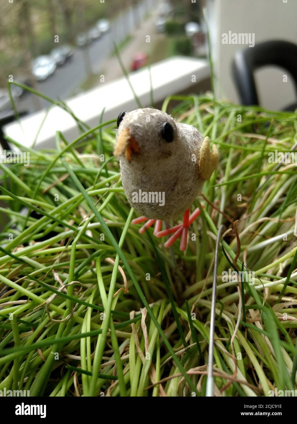 Vertical closeup shot of an artificial bird on top of an indoor plant ...
