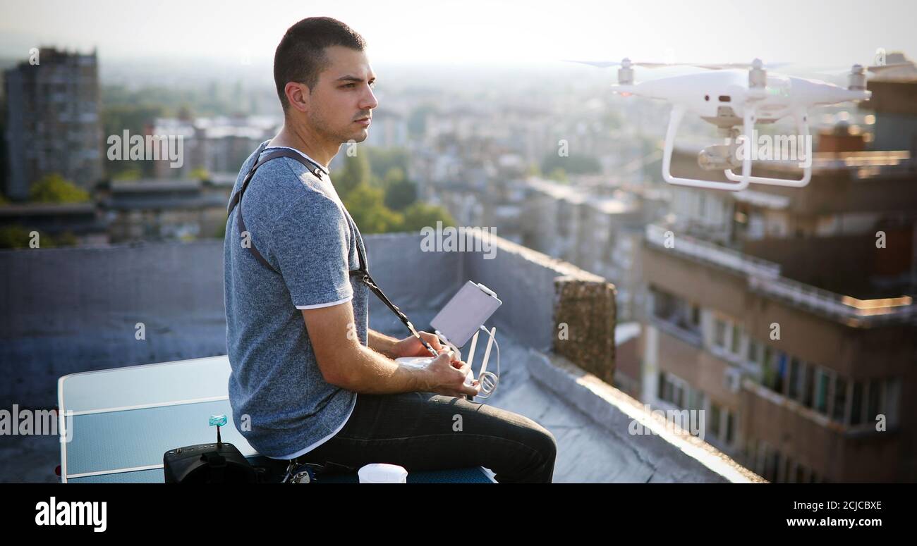 Man operating a drone with remote control on rooftop Stock Photo - Alamy