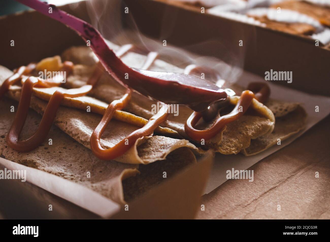 Shot of crepes with caramel and chocolate creme, preparation Stock ...