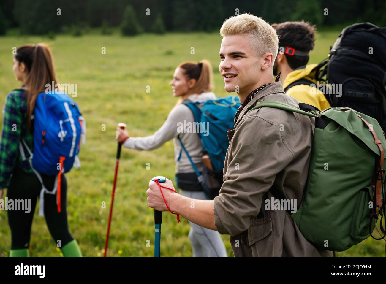 Group of friends hiking together outdoors exploring the wilderness and ...
