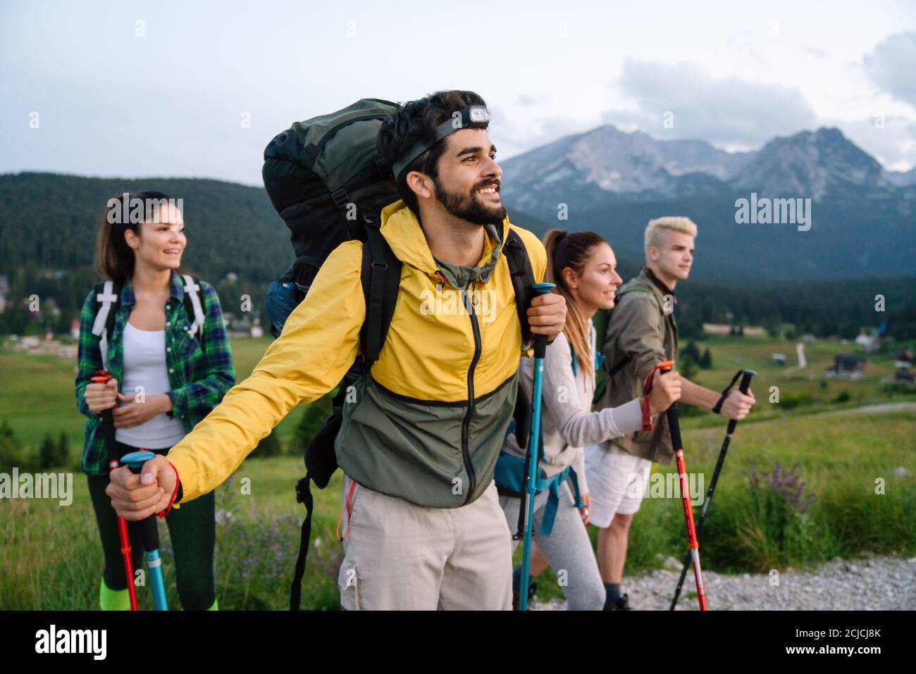Group of fit healthy friends trekking in the mountains Stock Photo - Alamy