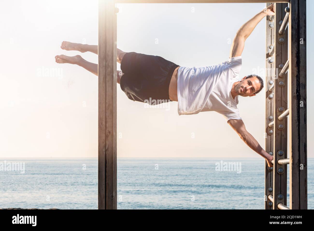 Athletic Caucasian male working out on the beach in the early morning ...