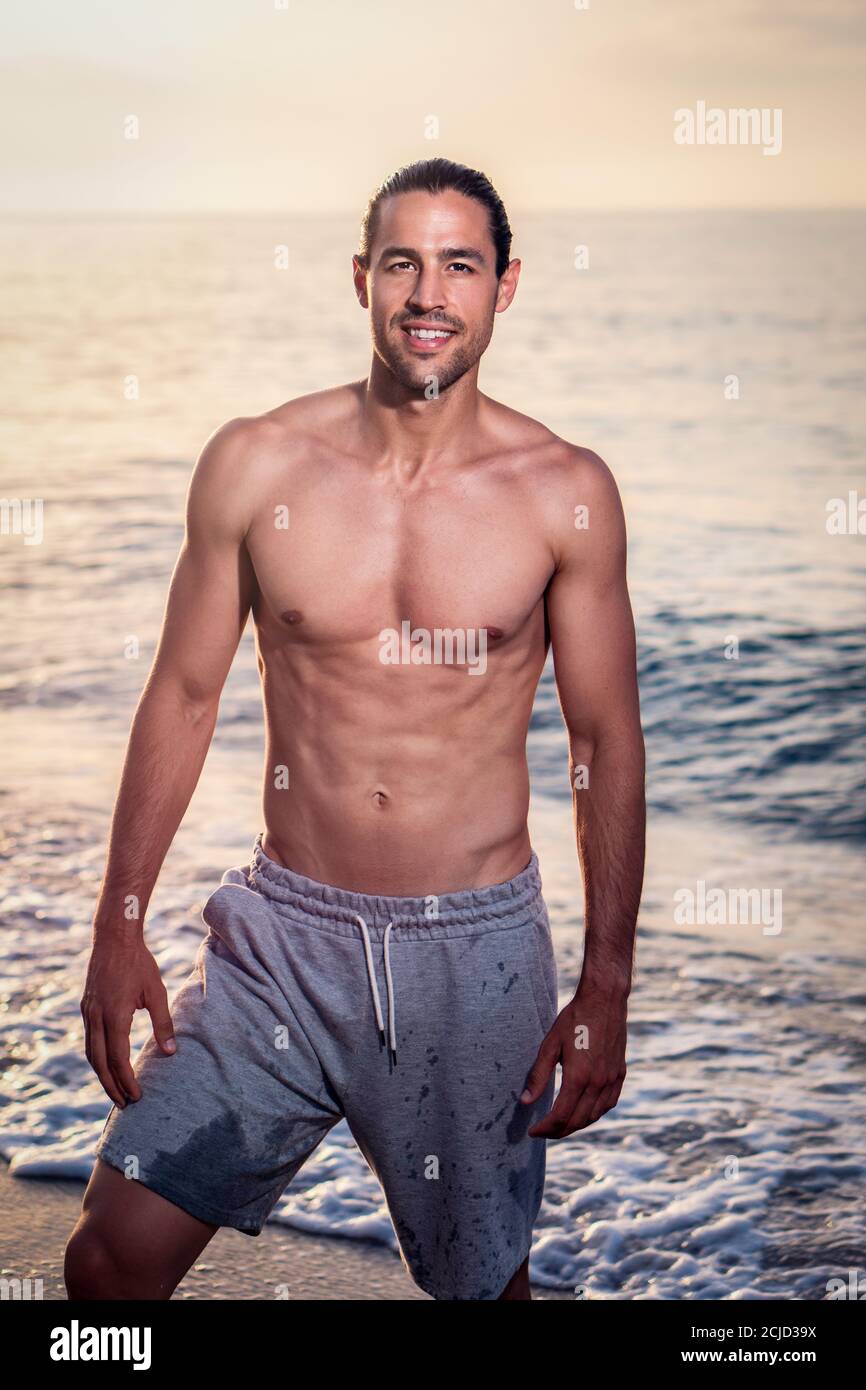 Athletic Caucasian male working out on the beach in the early morning ...