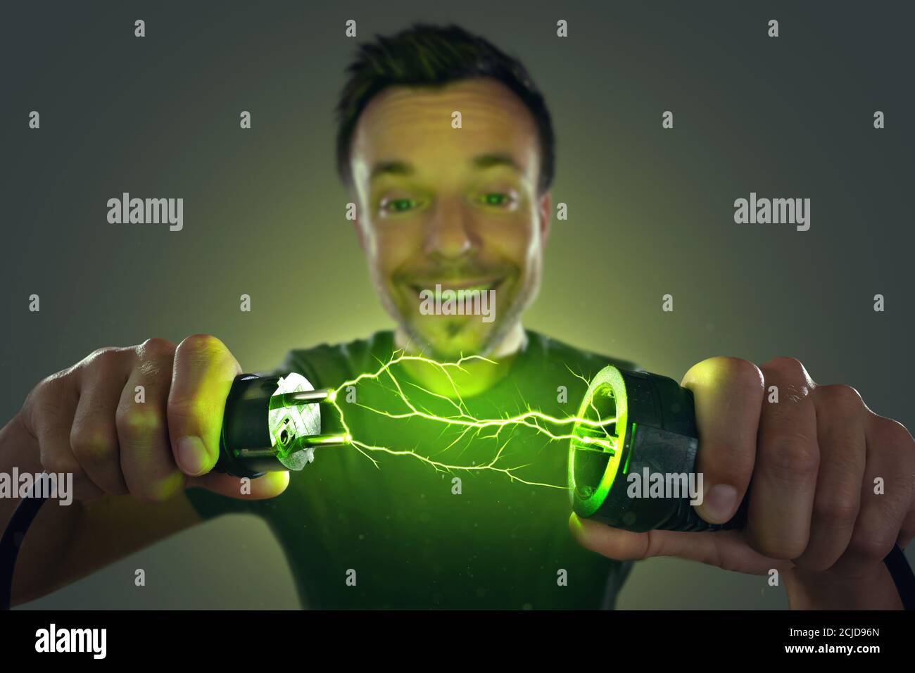 Man connecting green energy power plug Stock Photo - Alamy