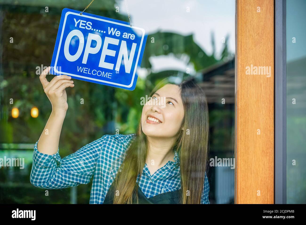 Asian young woman setting open sign at the shop glasses for welcome the ...