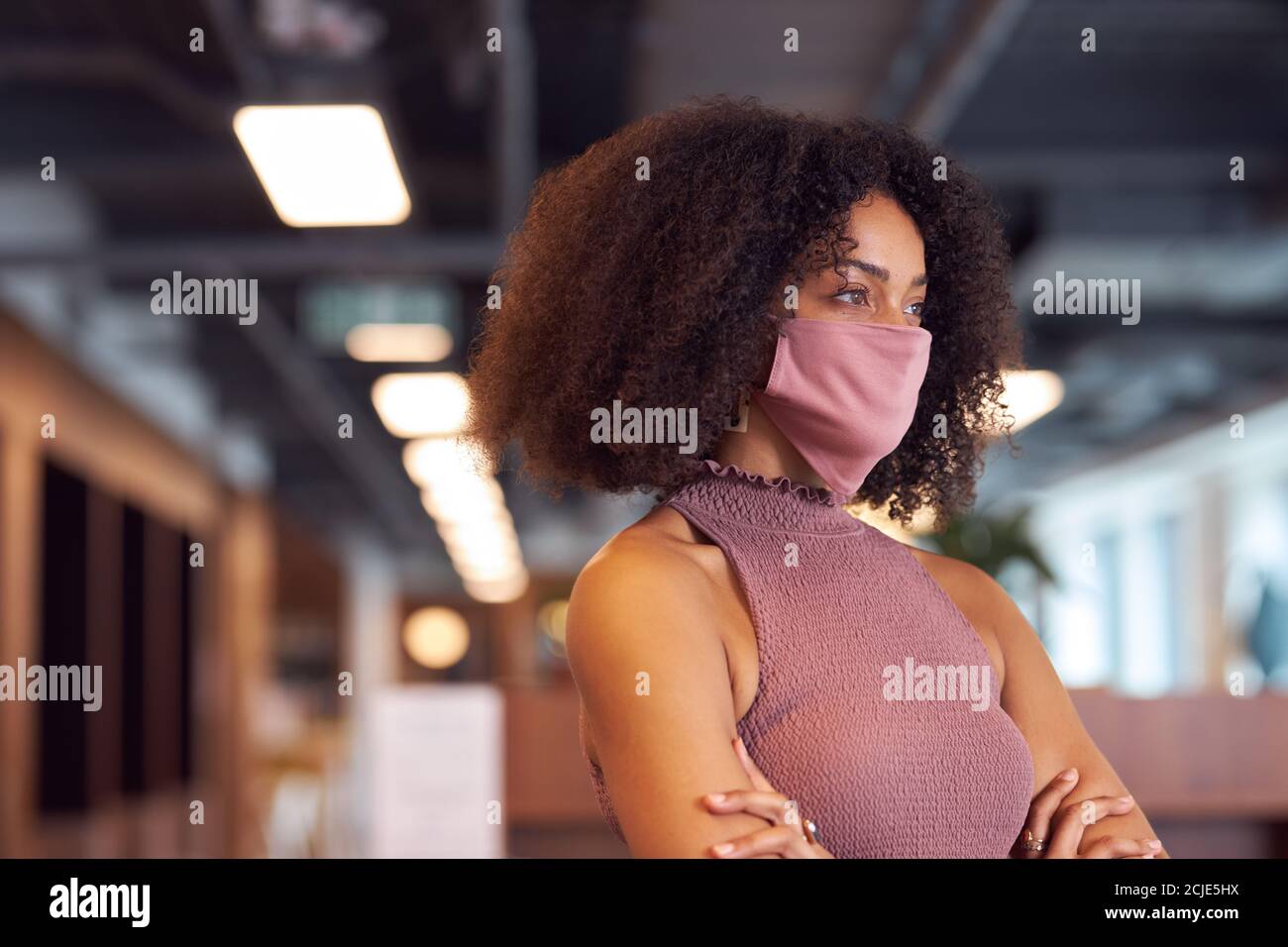 Businesswoman Wearing Face Mask In Modern Open Plan Office During Covid ...