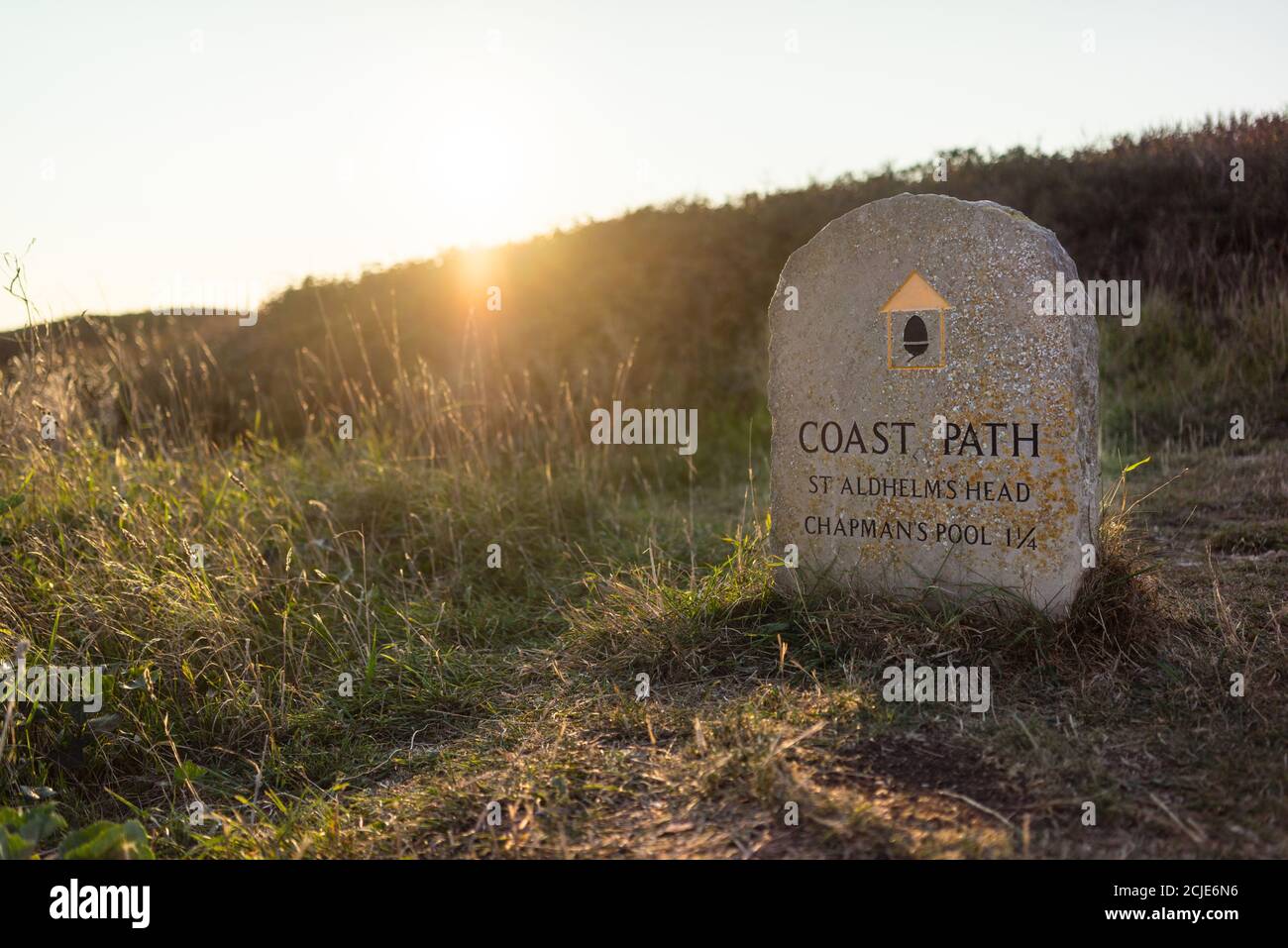 Sun setting over a South West Coast Path stone way marker at St Aldhelm ...