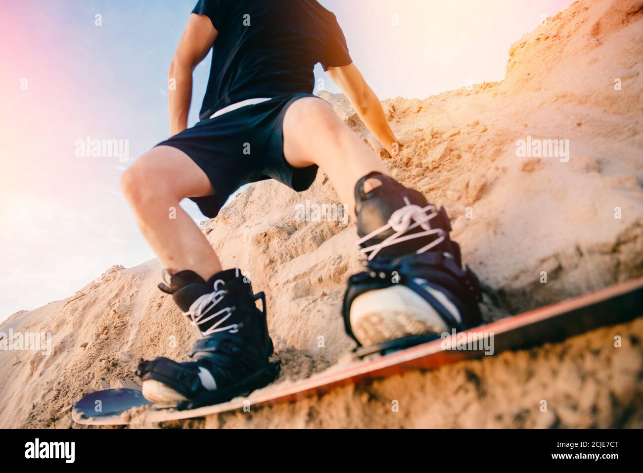 Extreme descent sand on snowboard in desert. Male snowboarder on dunes ...