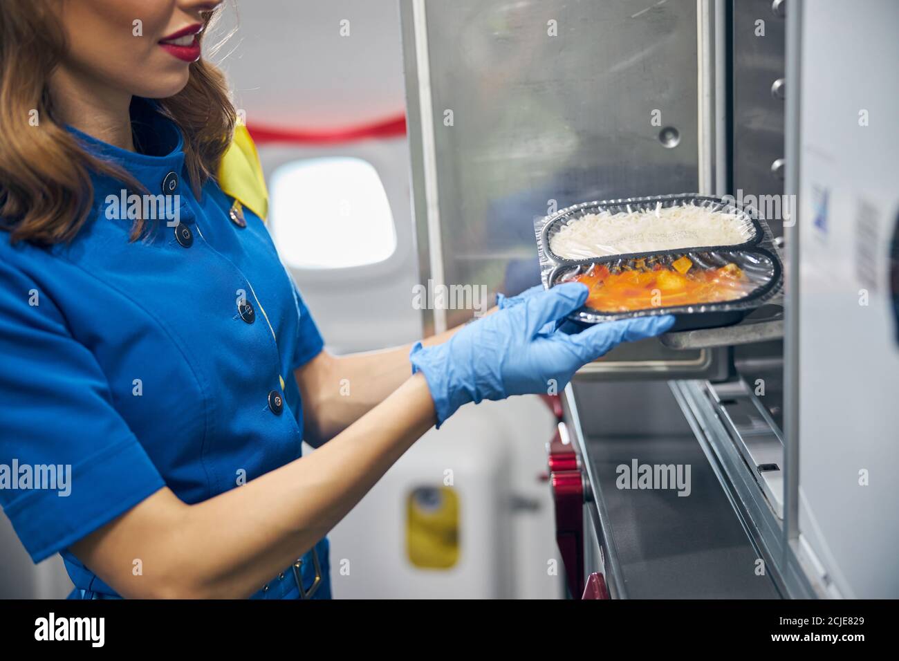 Stewardess serving food to the passengers at the kitchen of commercial ...