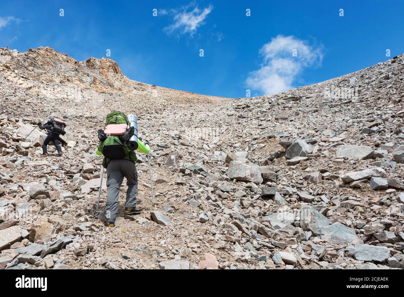 Group of tourists with backpacks lift up mountain trail to glacier in ...