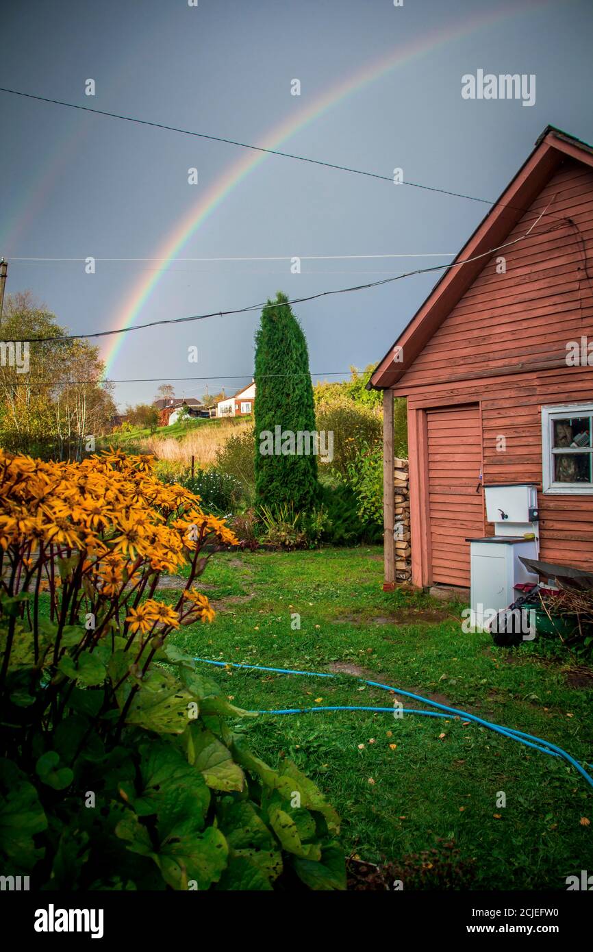 pink country house in a village in an autumn garden with a blue sky and ...