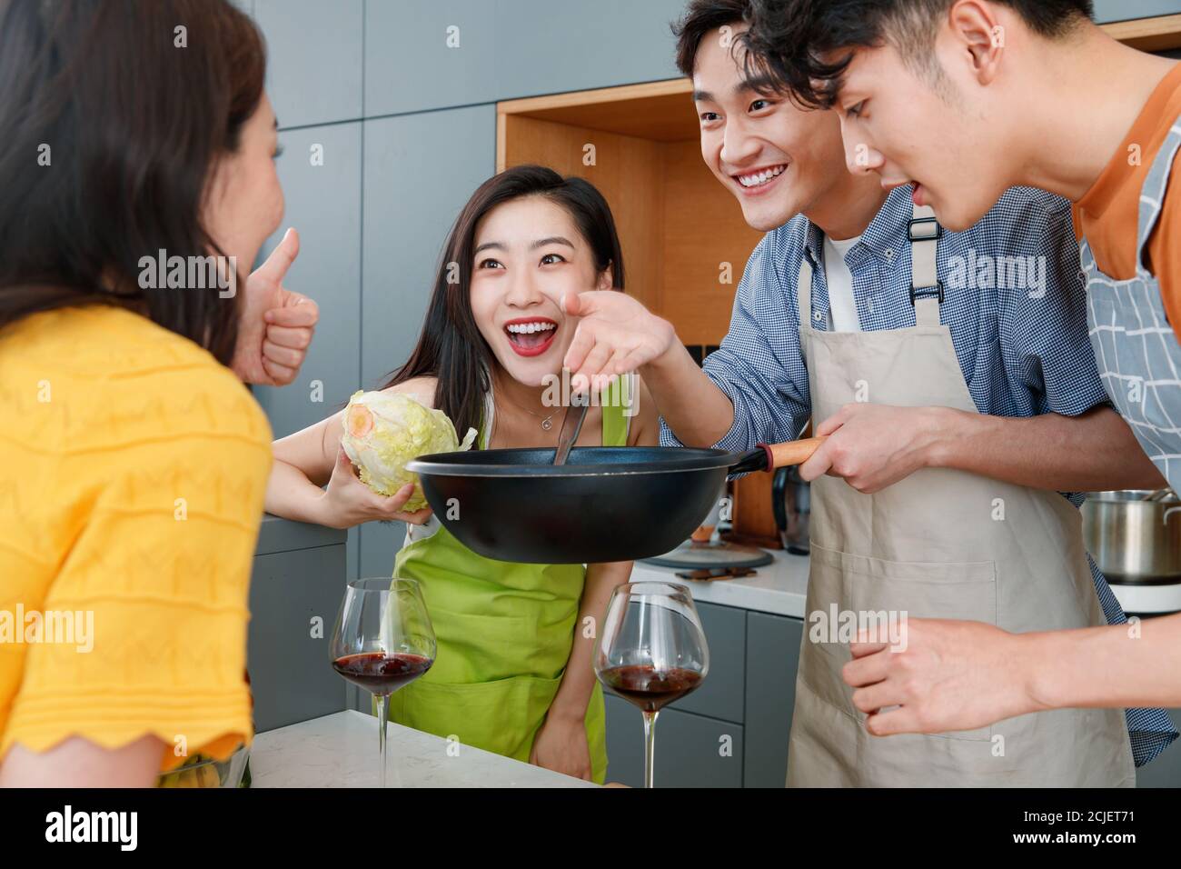 Happy young people cook in the kitchen Stock Photo - Alamy